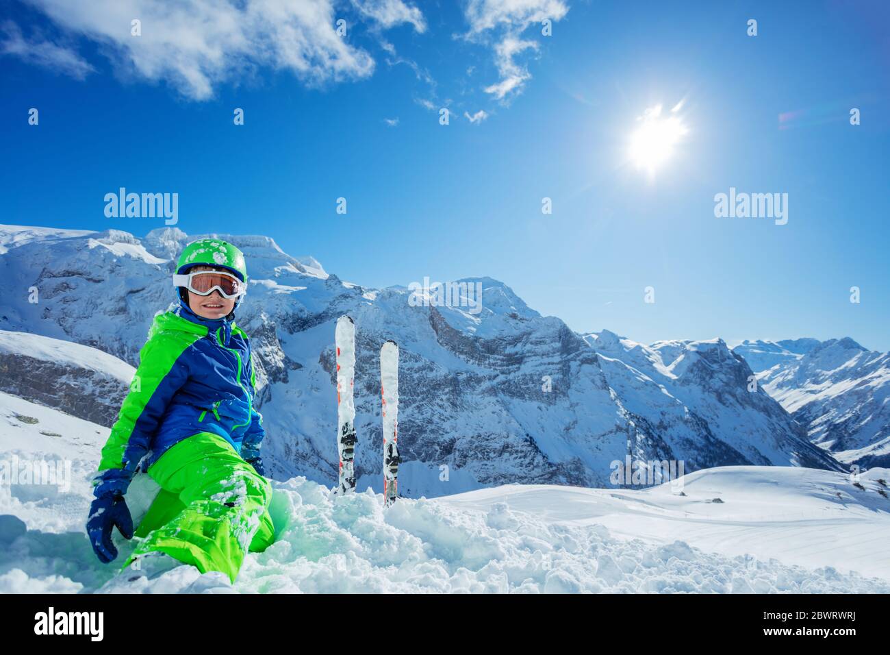 Little boy having fun skiing in Alpine mountains portrait with panorama ...