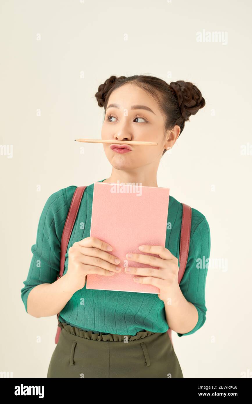 Young teenage student freaking out and holding her pencil between nose ...