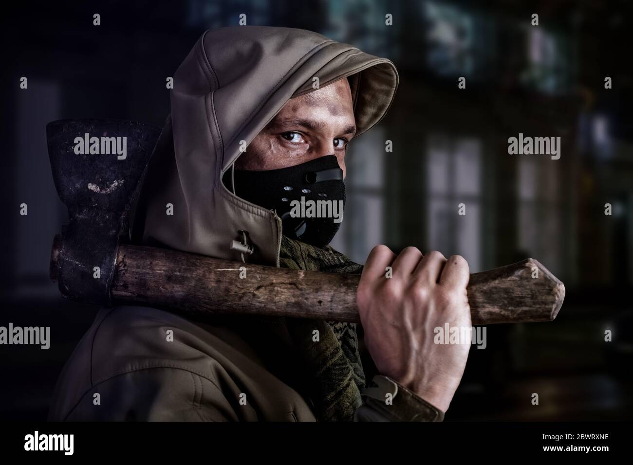 Dark photo of Young handsome man with ax wearing medical protactive ...