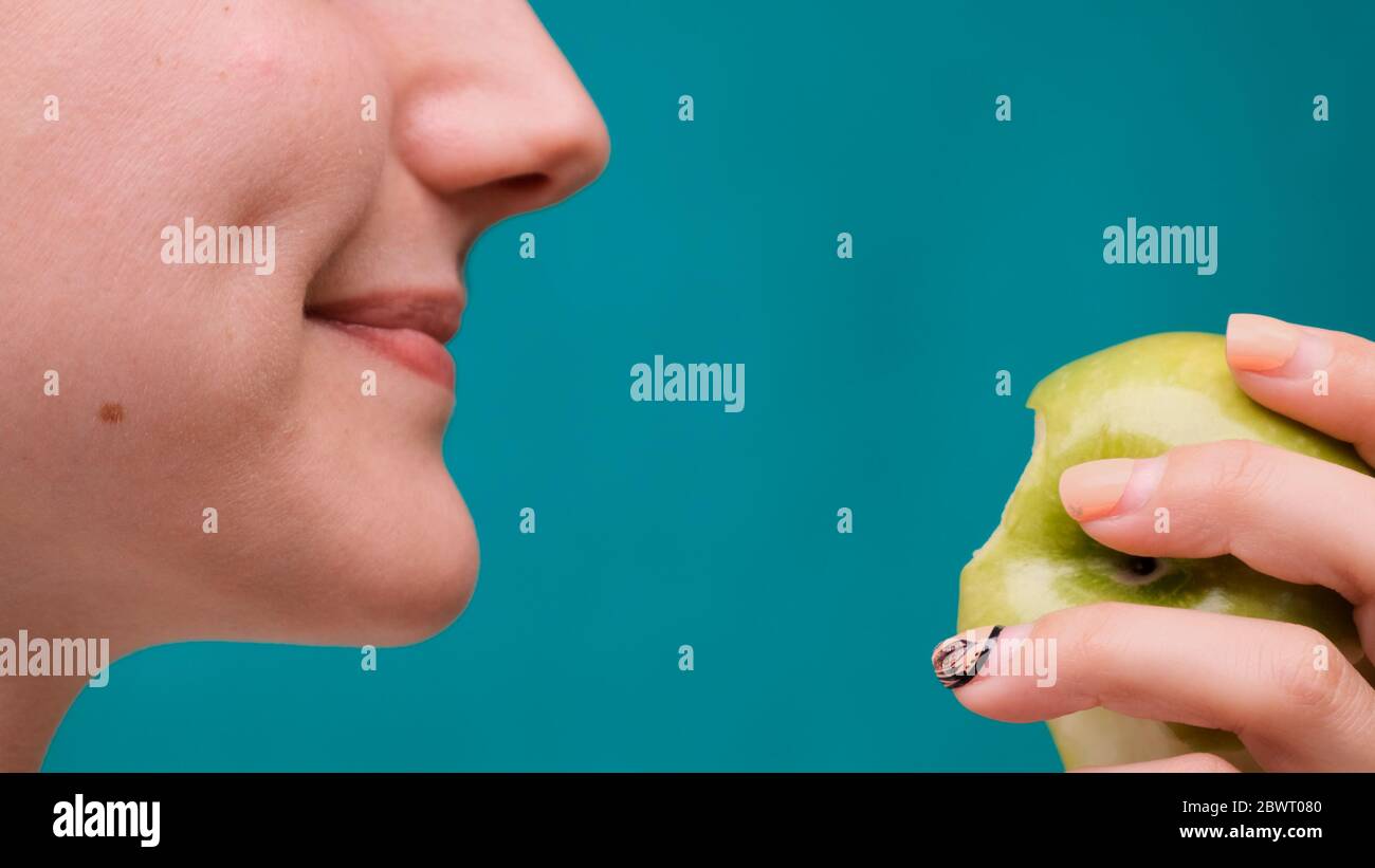 Healthy eating and healthy teeth or diet, young woman bites a fresh ...