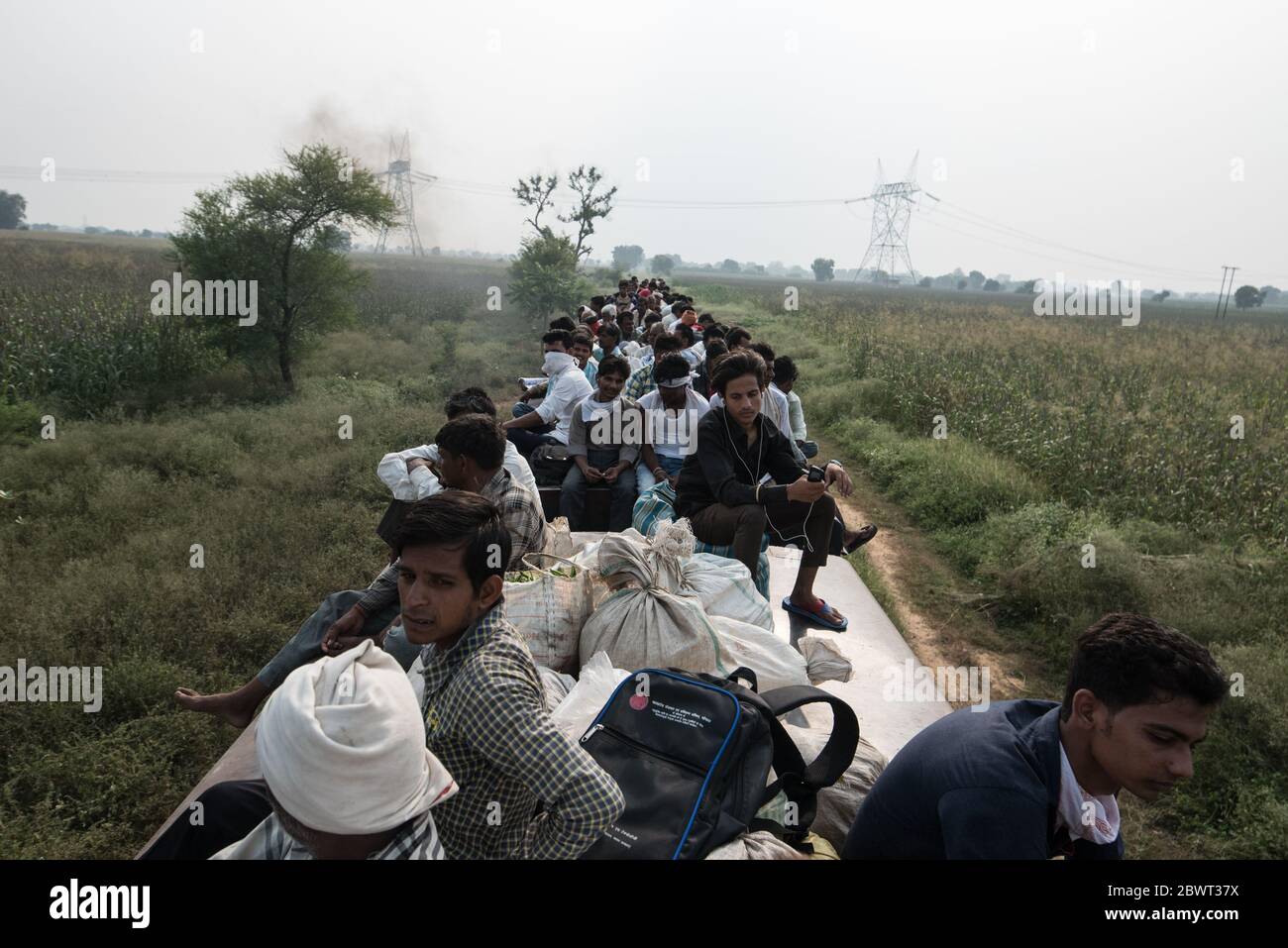 Men on top of overcrowded train passing through countryside in Madhya ...