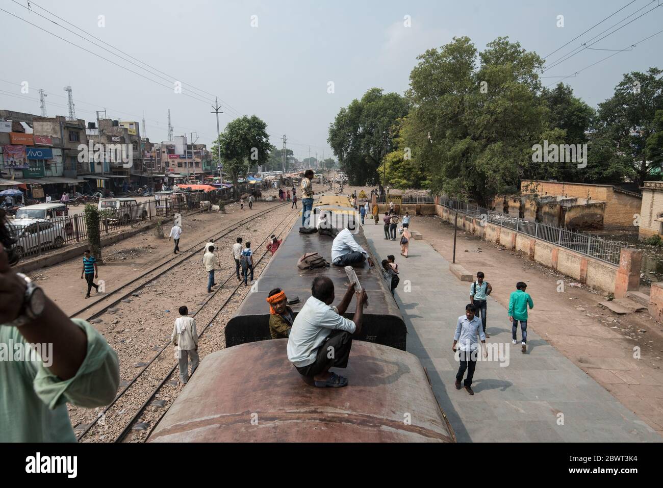Men on top of overcrowded train passing through countryside in Madhya ...