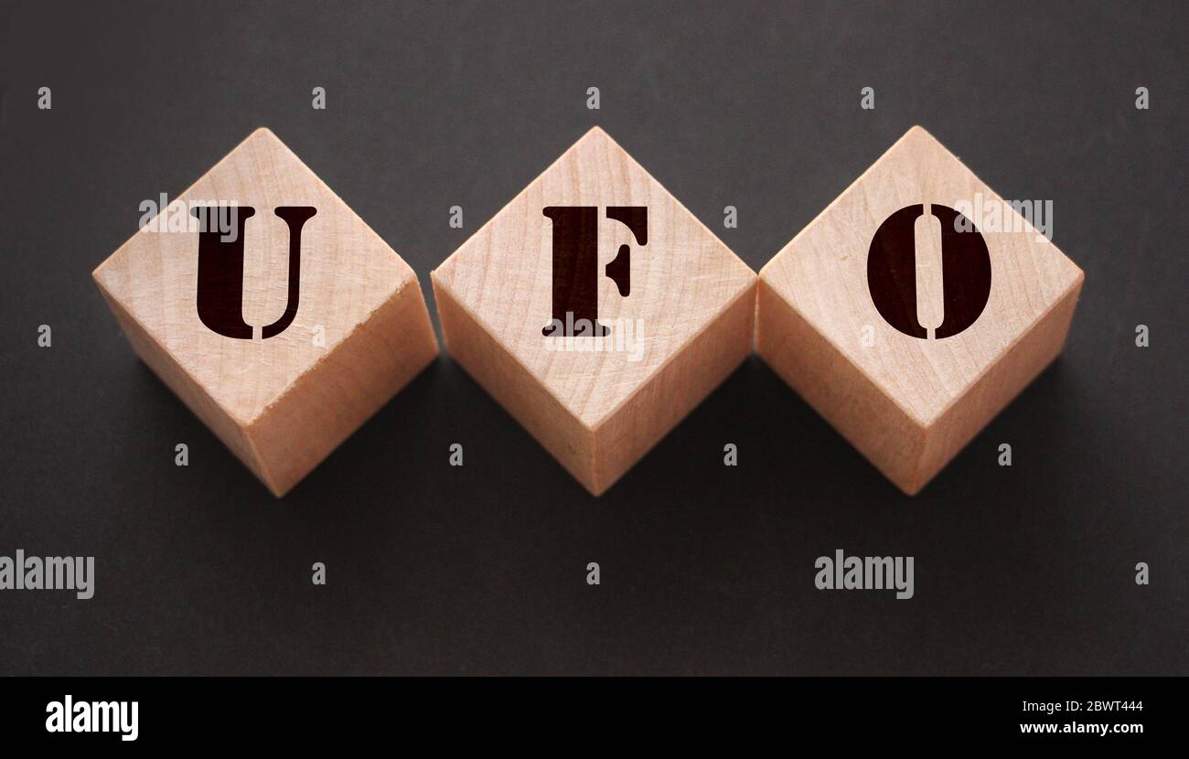 The word UFO written on wooden cubes isolated on a black background ...