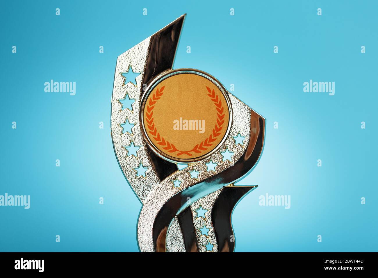 Superprize statuette made of gold on a blue background Stock Photo - Alamy