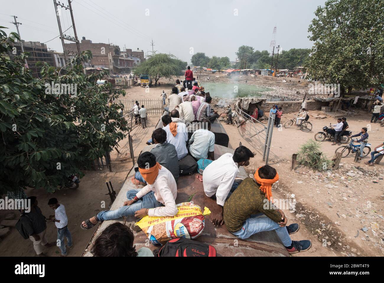Men on top of overcrowded train passing through countryside in Madhya ...