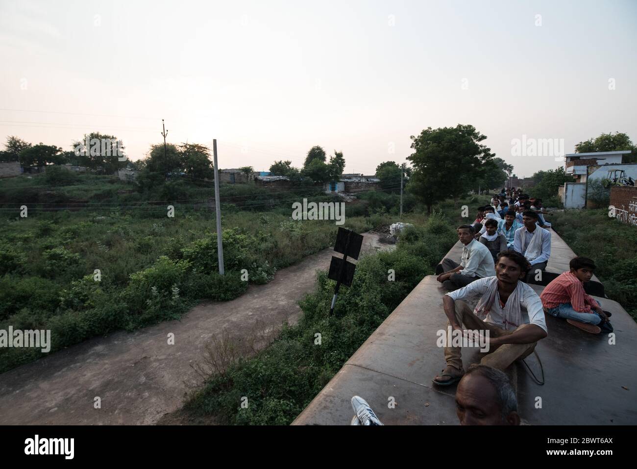 Men on top of overcrowded train passing through countryside in Madhya ...