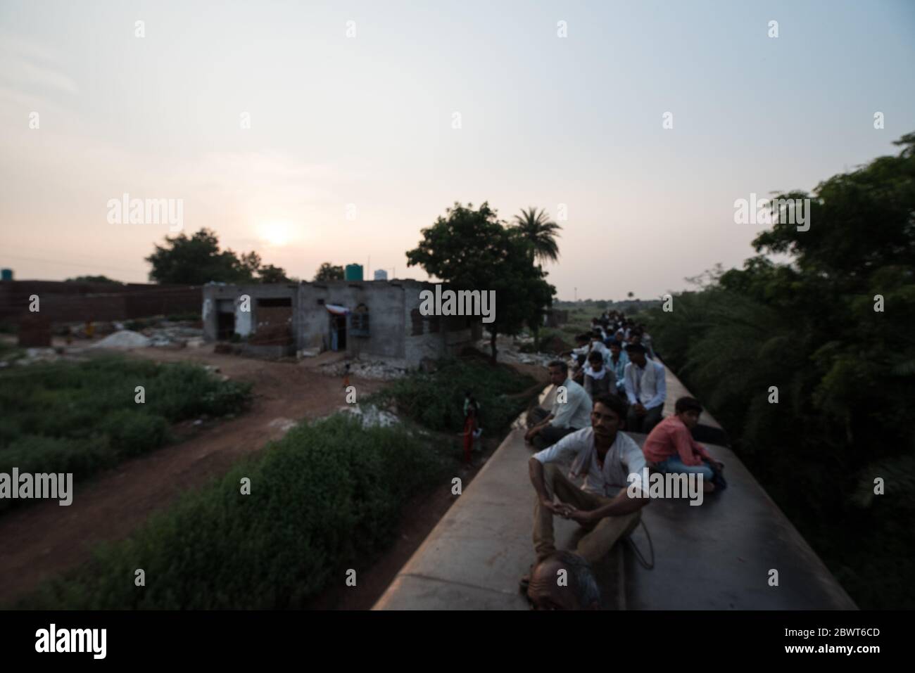 Men on top of overcrowded train passing through countryside in Madhya ...
