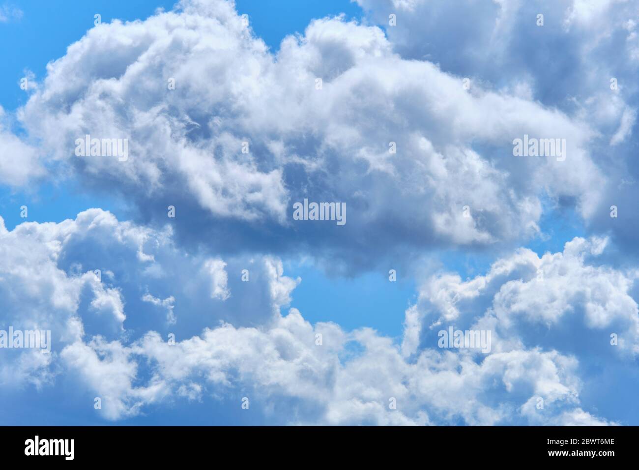 Dense big white clouds on a blue background Stock Photo - Alamy