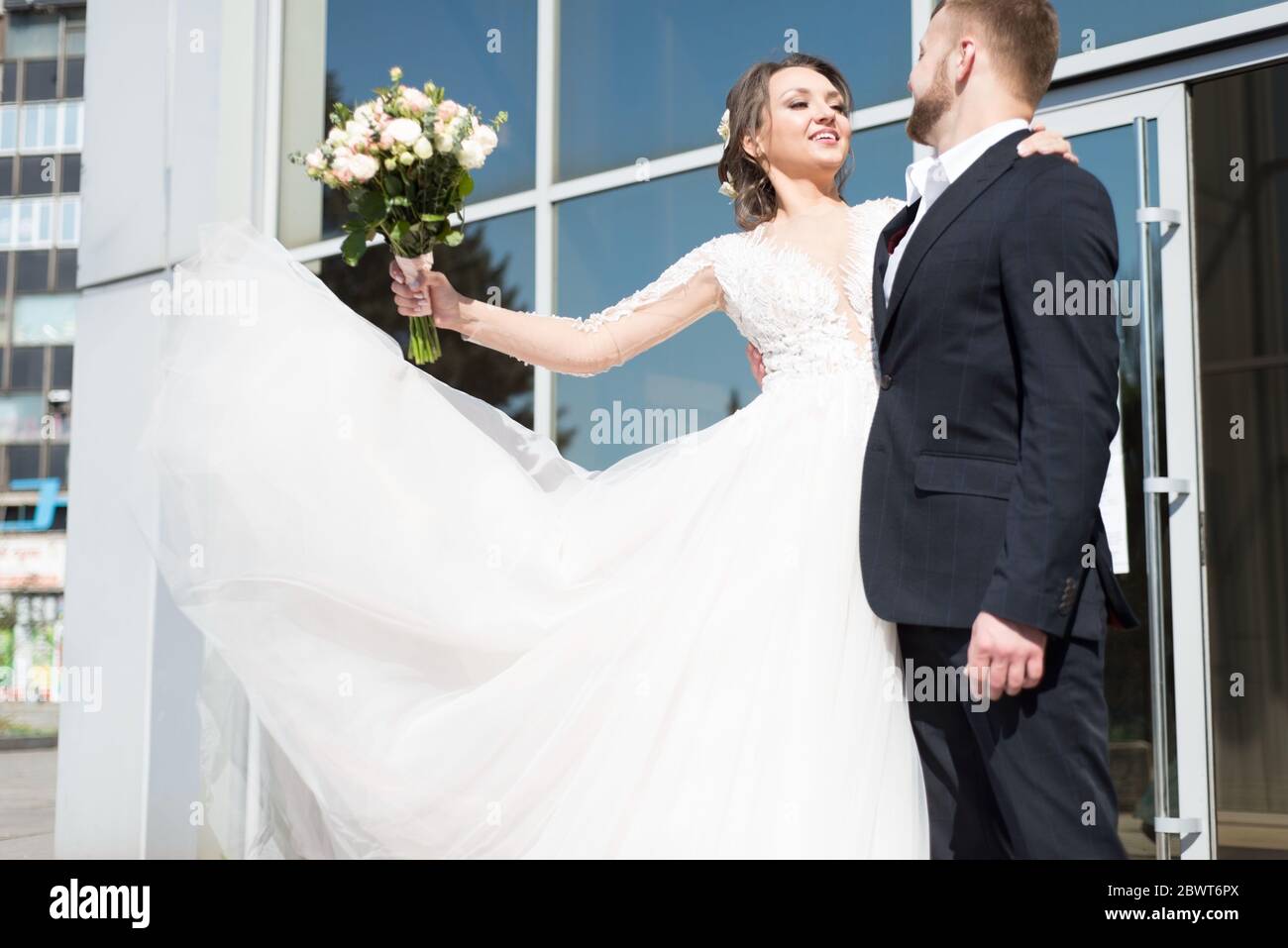 The bride lifts the bouquet up, a flying wedding dress, the groom ...