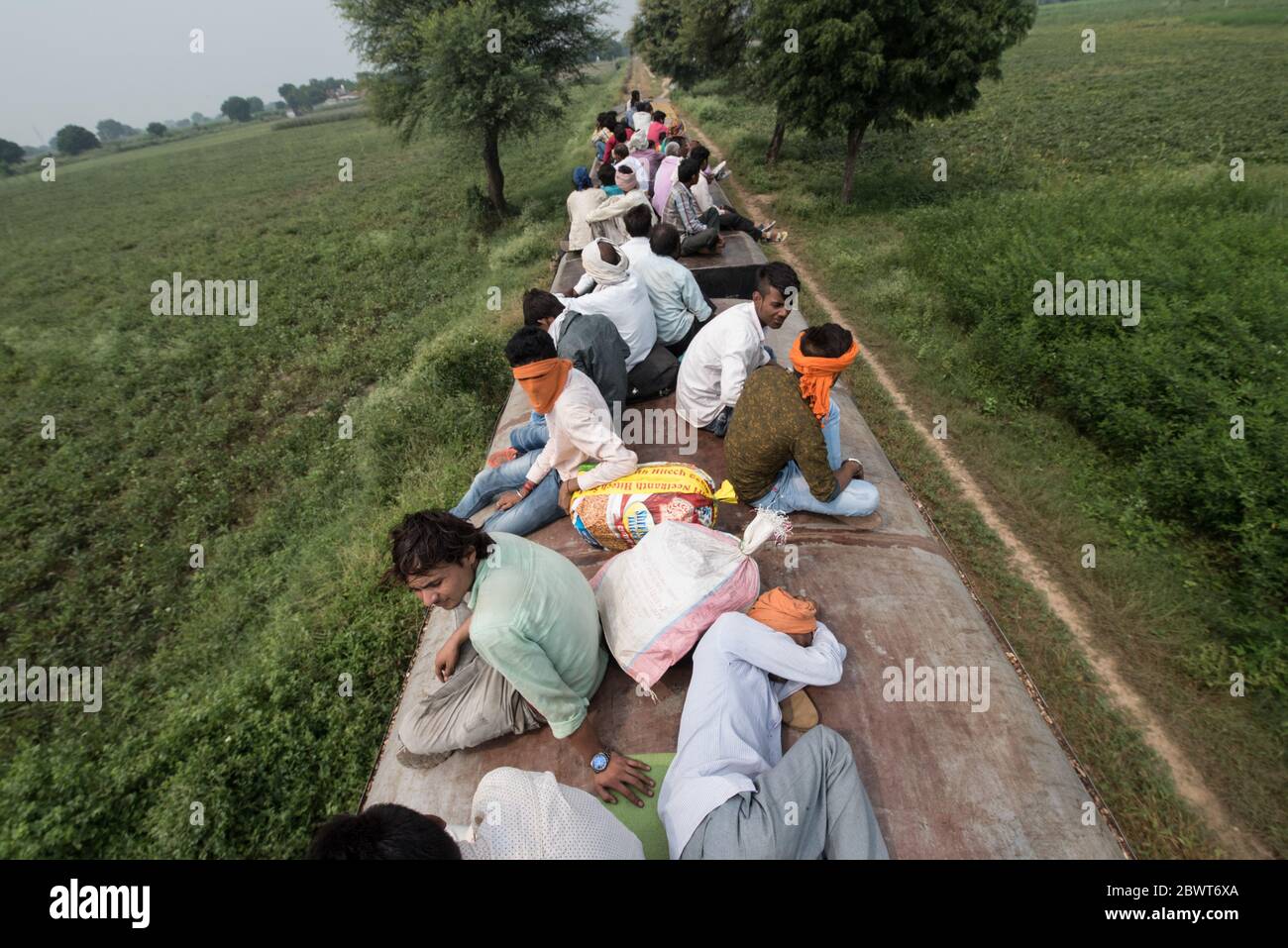 Men on top of overcrowded train passing through countryside in Madhya ...