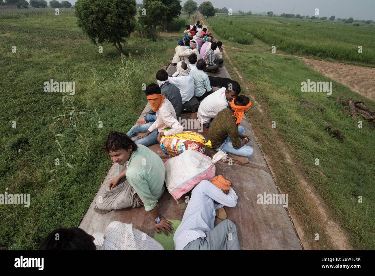 Men on top of overcrowded train passing through countryside in Madhya ...