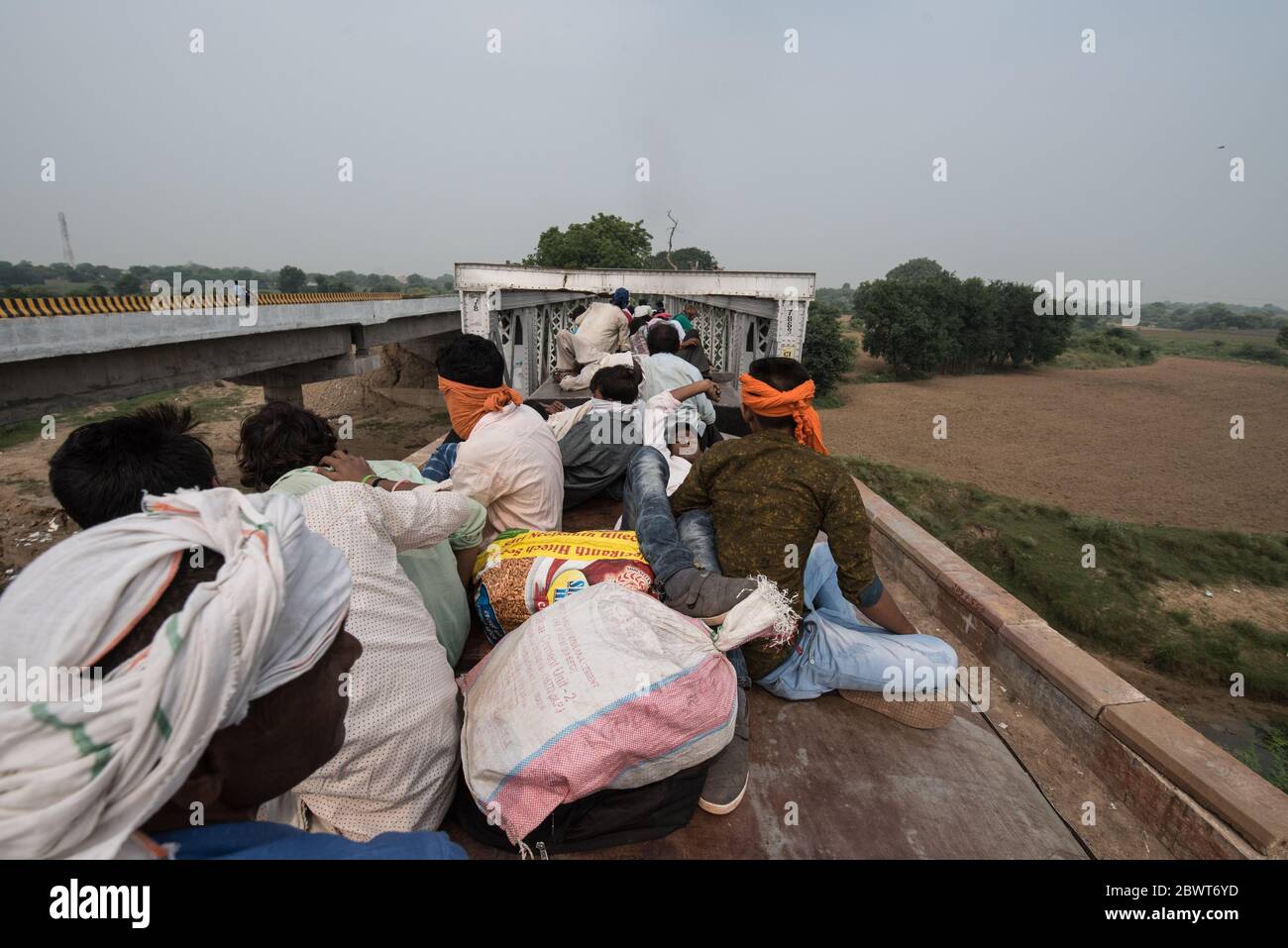 Men on top of overcrowded train passing through countryside in Madhya ...