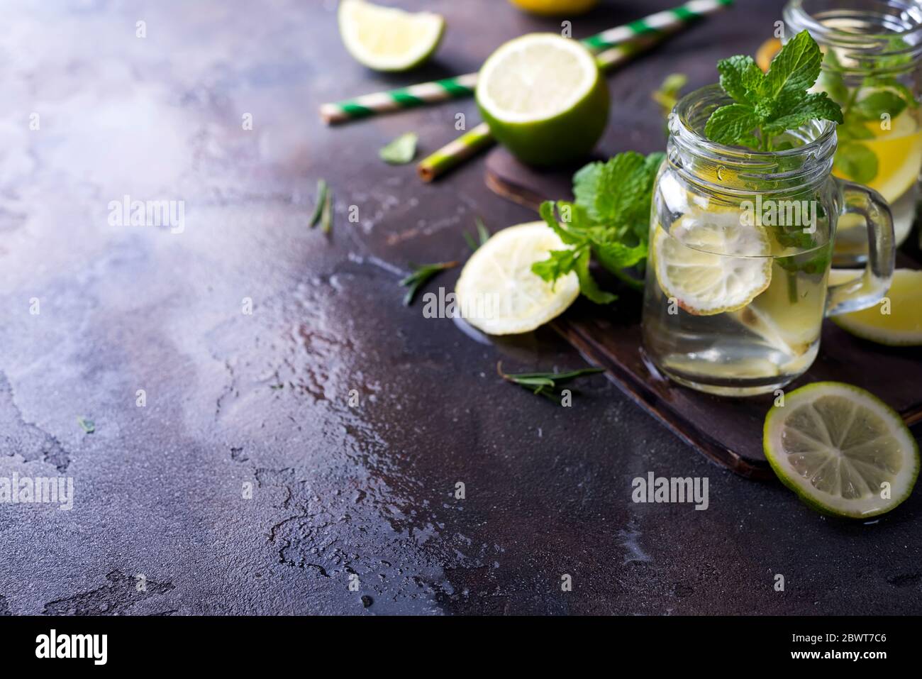Homemade fresh lemonade with citrus slice fruits on a grey concrete ...
