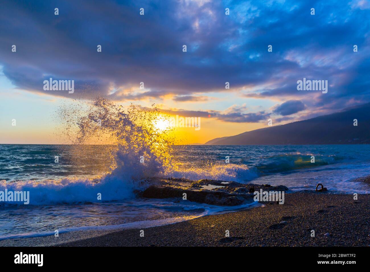 Beautiful shoreline scene with waves at sunset beams Stock Photo - Alamy