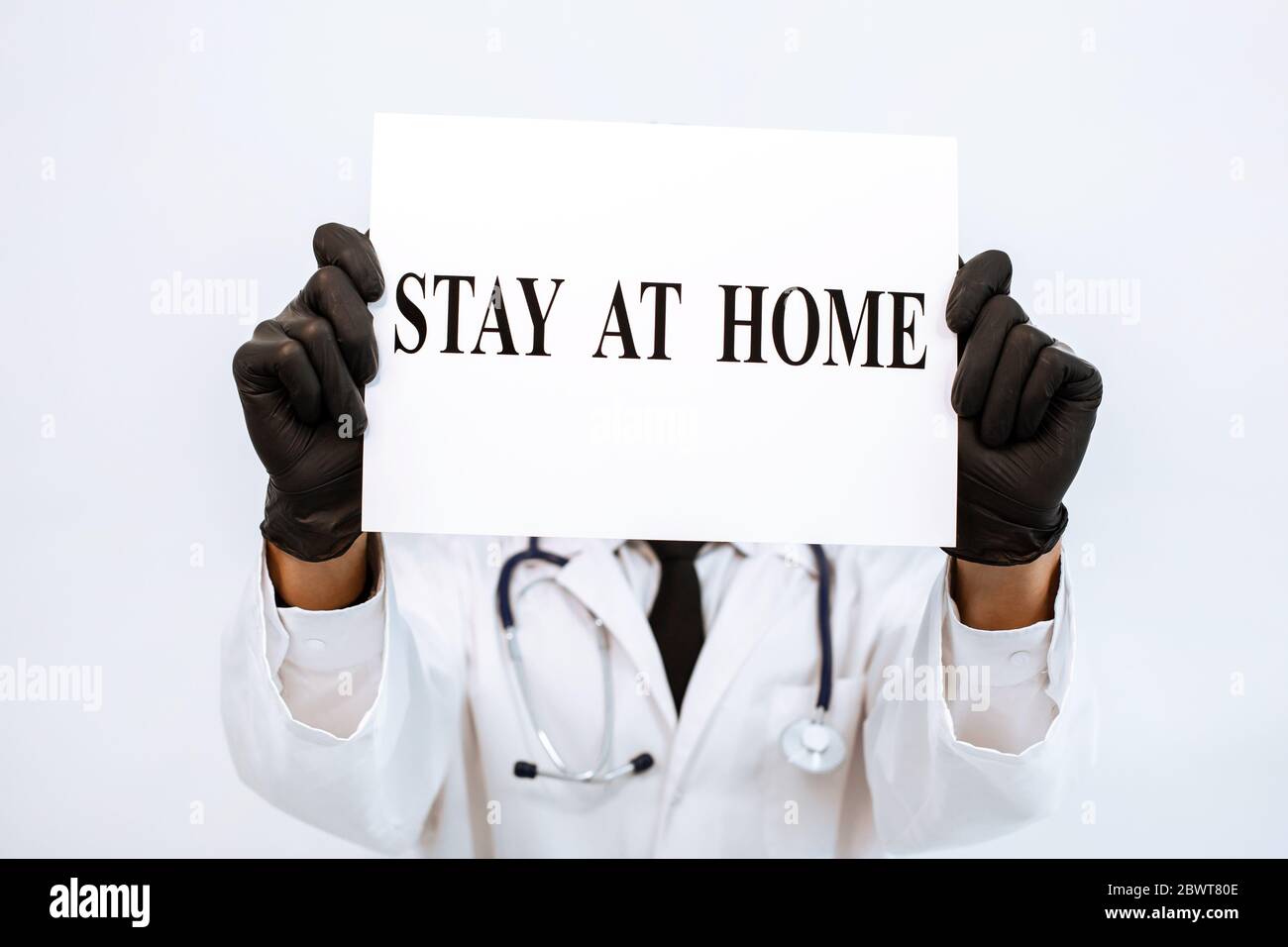 warning stay at home in the hands of the doctor Stock Photo - Alamy