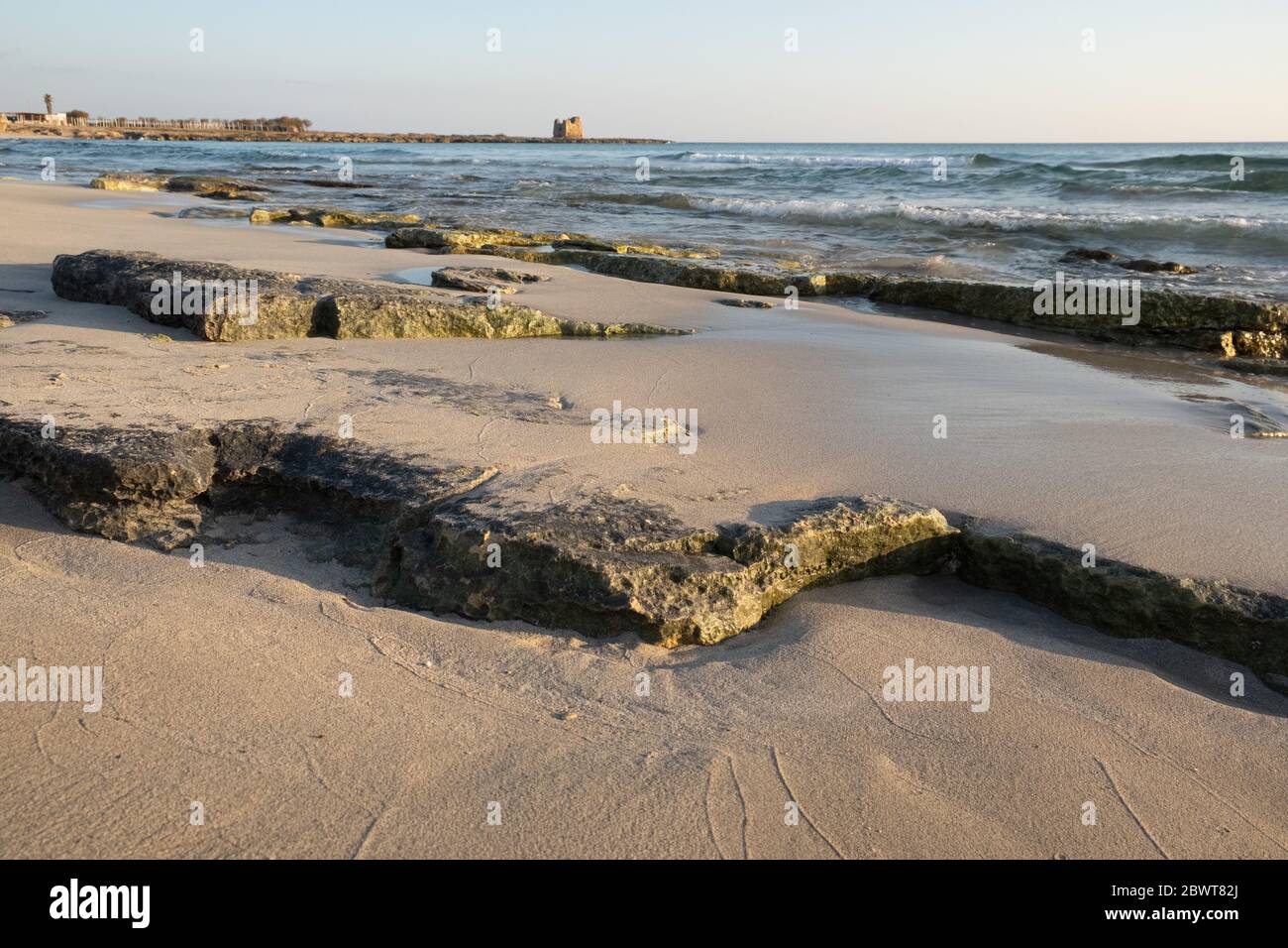 Sandy beach with flat rocks are bathed by the waters of the Jonio Sea ...