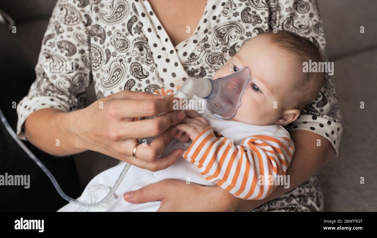 Infant getting breathing treatment from mother while suffering from ...