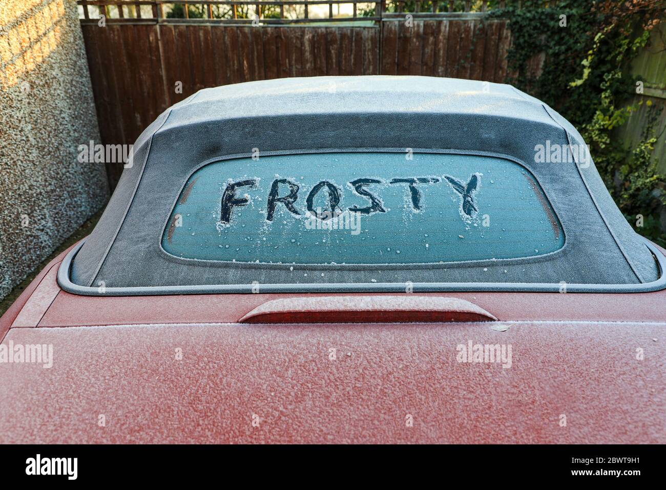The word frosty written on the rear window of a frost covered car ...