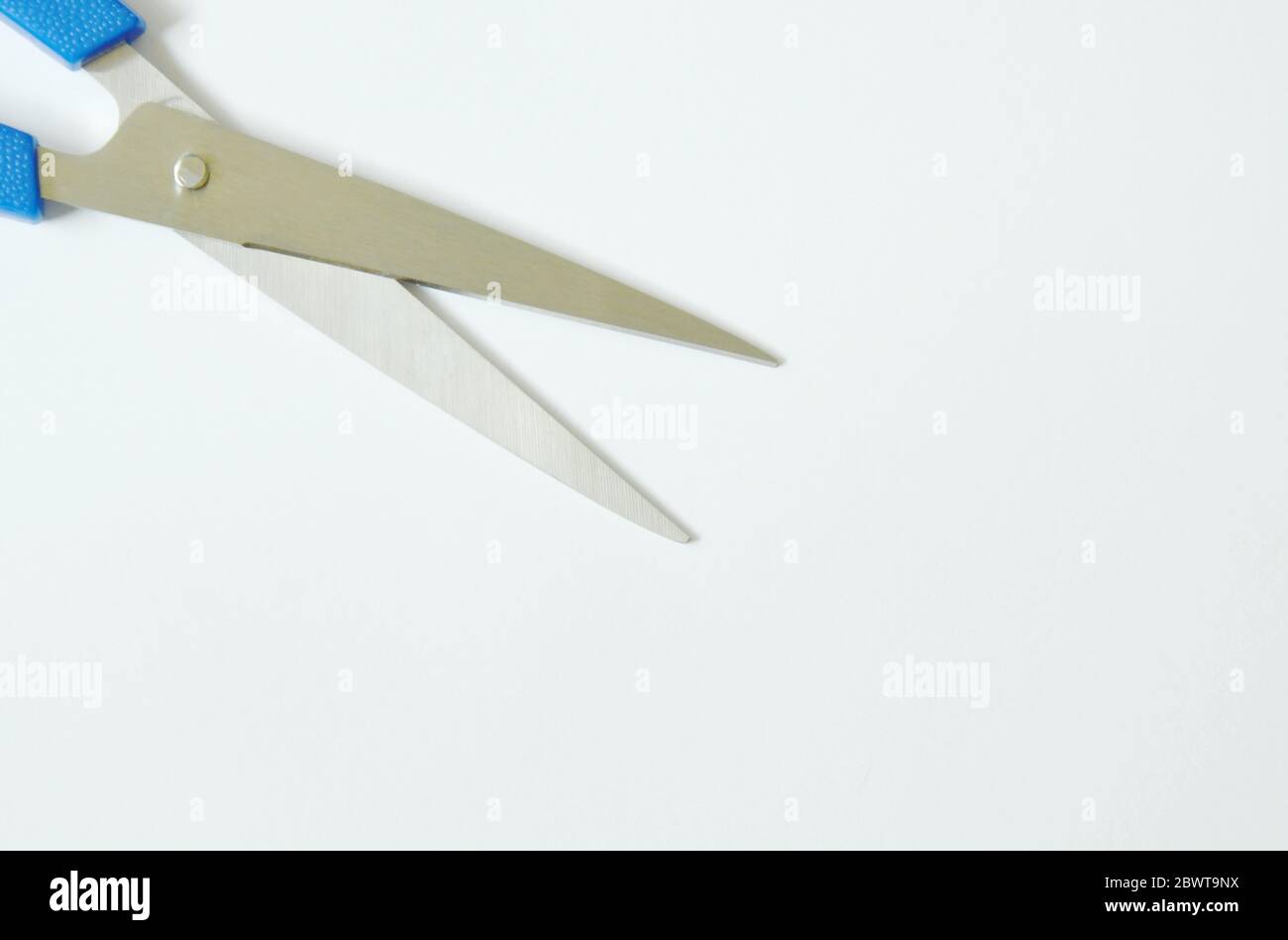 scissor with blue handle on white background Stock Photo - Alamy