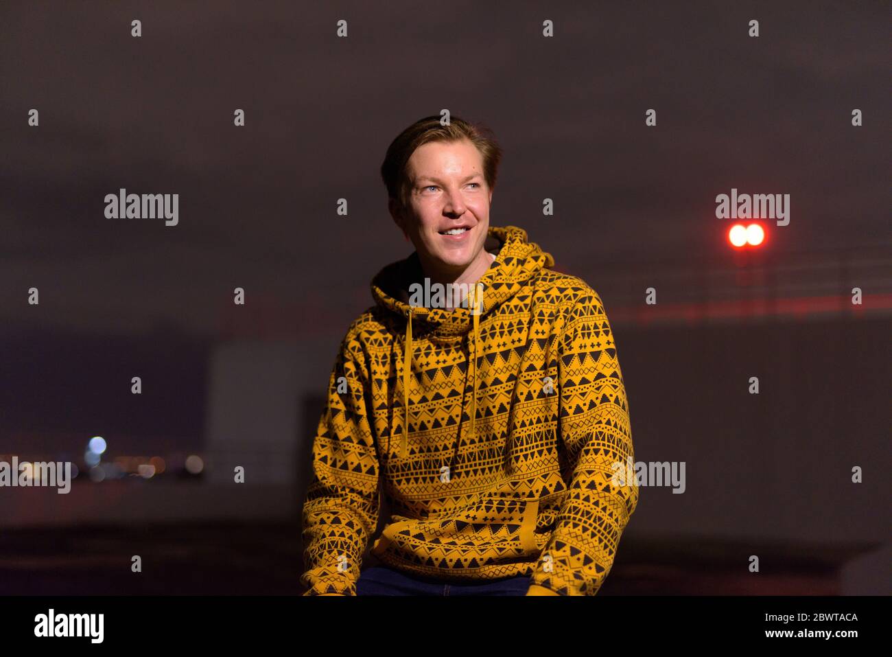 Happy young handsome man thinking at rooftop of the building during ...