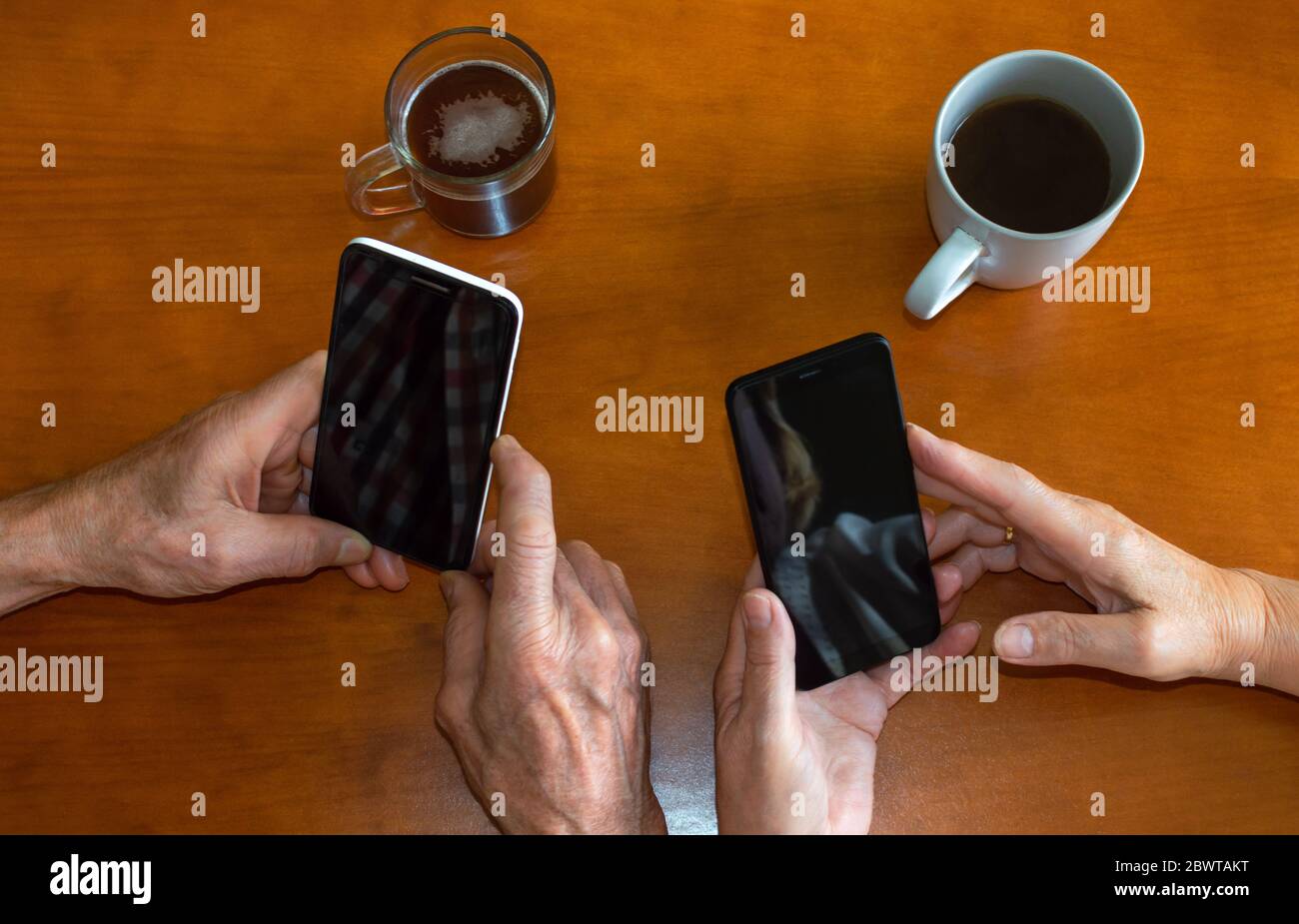 Top view of hands of old people using smartphones at home while ...