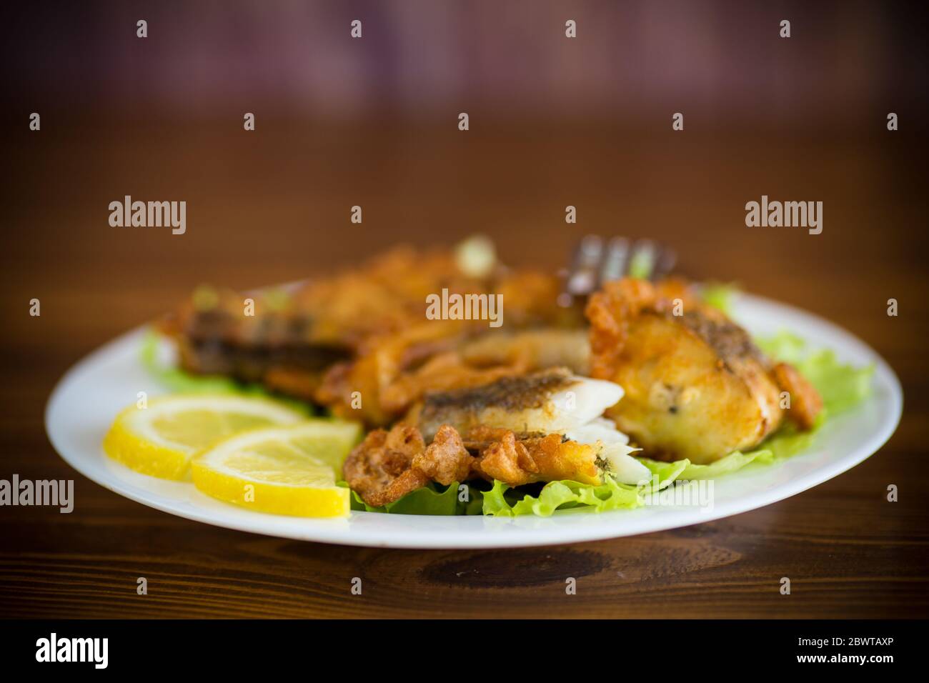 fried hake fish in batter with lettuce and lemon in a plate Stock Photo ...