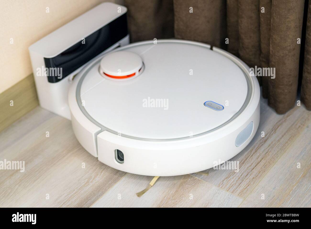 Vacuum cleaner robot on charging dock station Stock Photo - Alamy