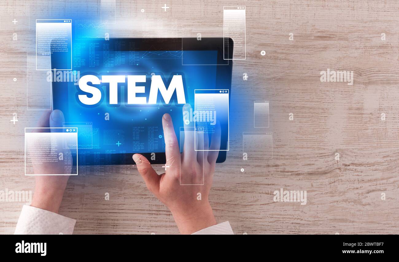 Close-up of a hand holding tablet with STEM abbreviation, modern ...