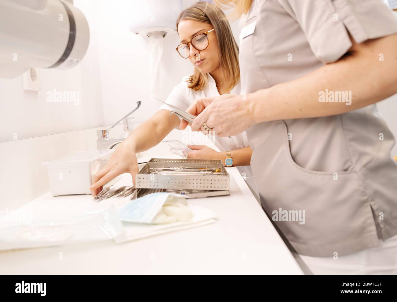 Side view of women in medical uniform preparing clean instruments for ...