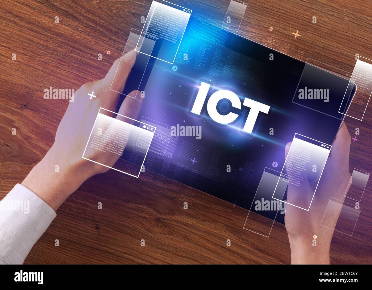 Close-up of a hand holding tablet with ICT abbreviation, modern ...