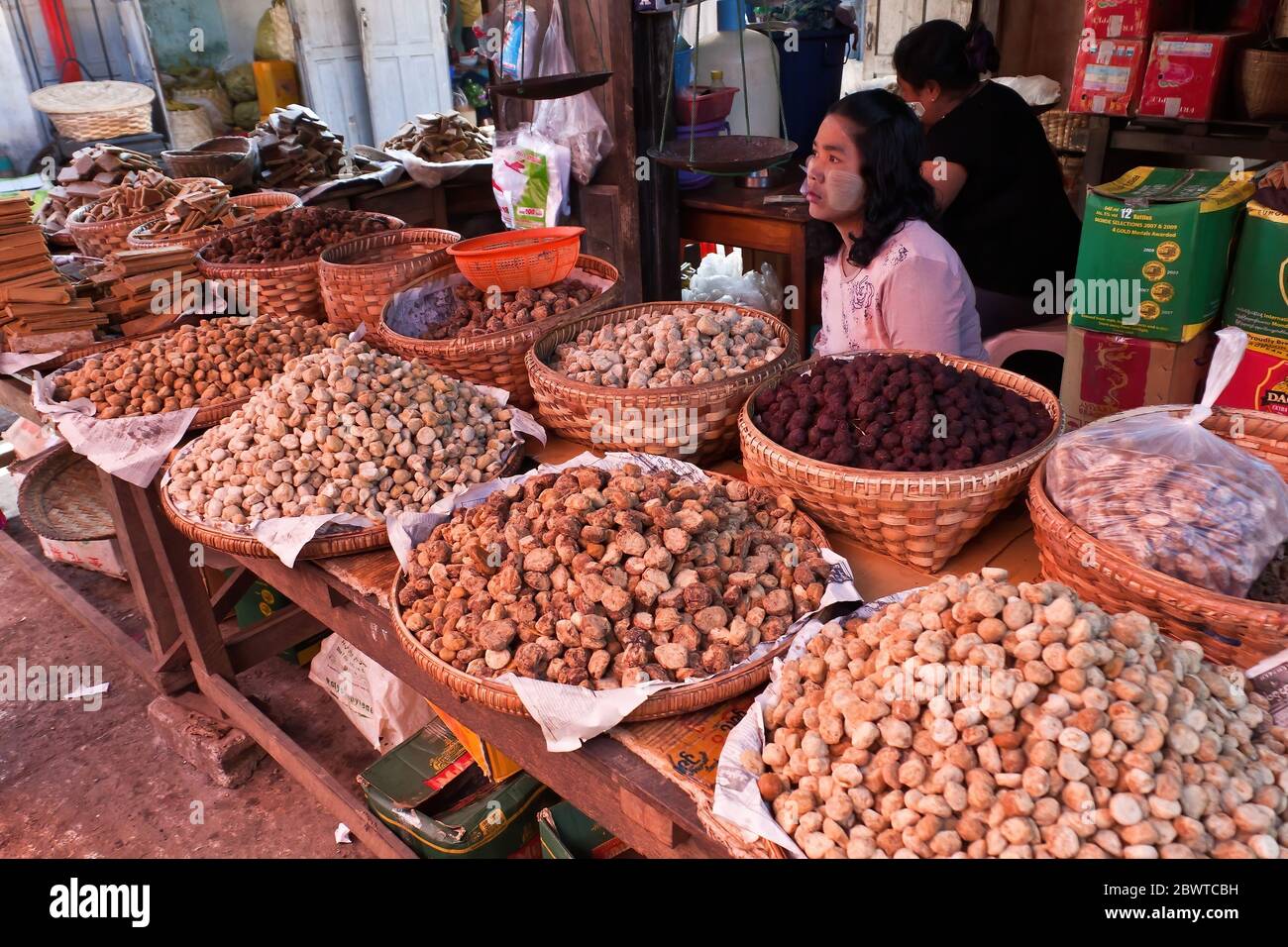 A young Burmese woman selling traditional natural cosmetics at a ...