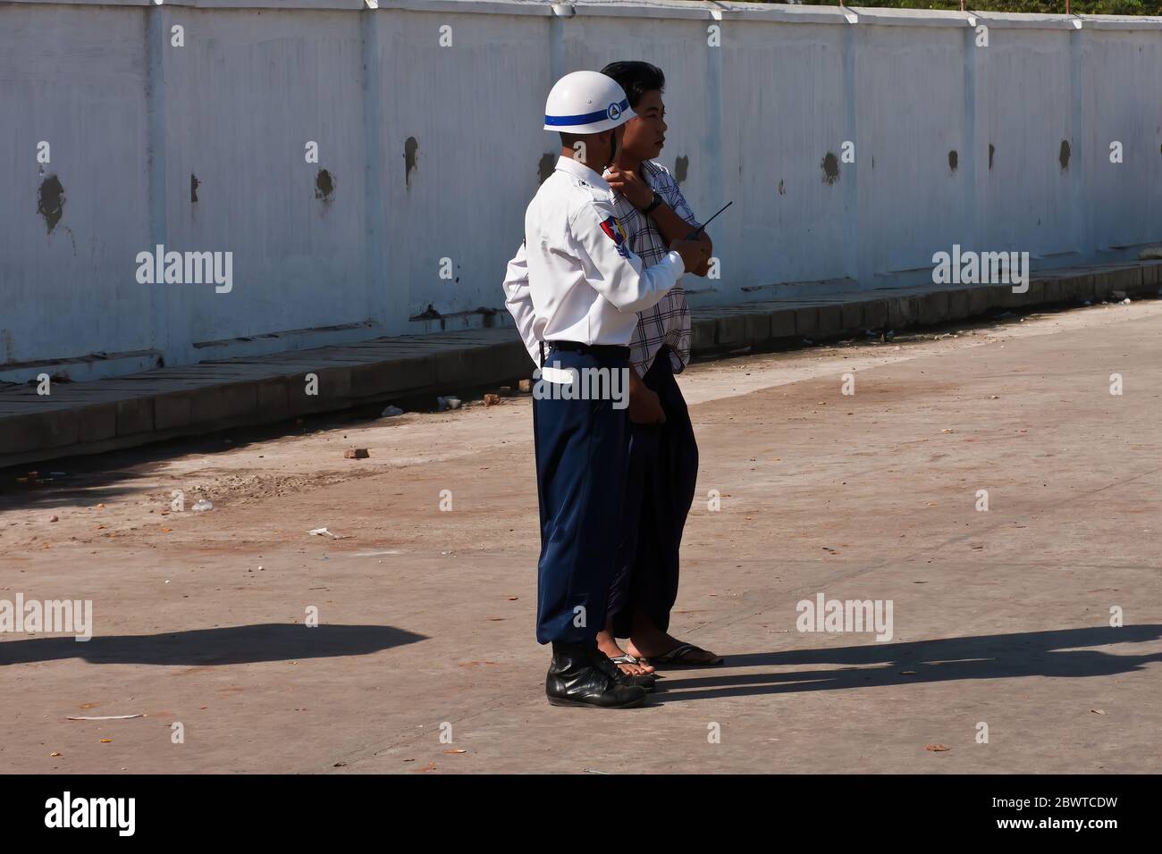 A Burmese policeman with a local man on the street of Yangon, Myanmar ...