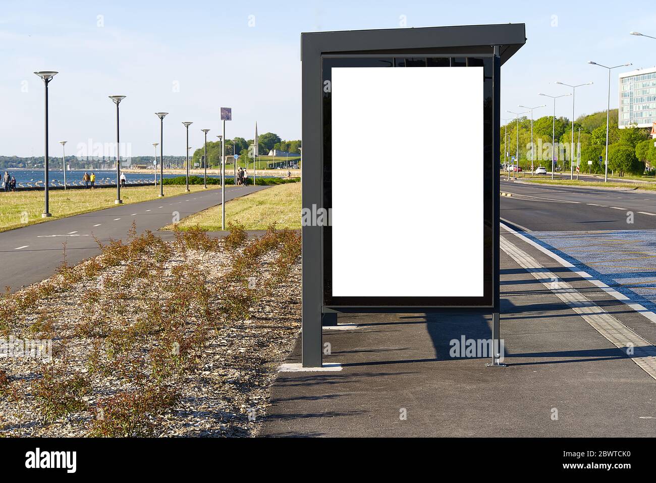 glass bus stop by the sea, with a white advertising space. Blank ...