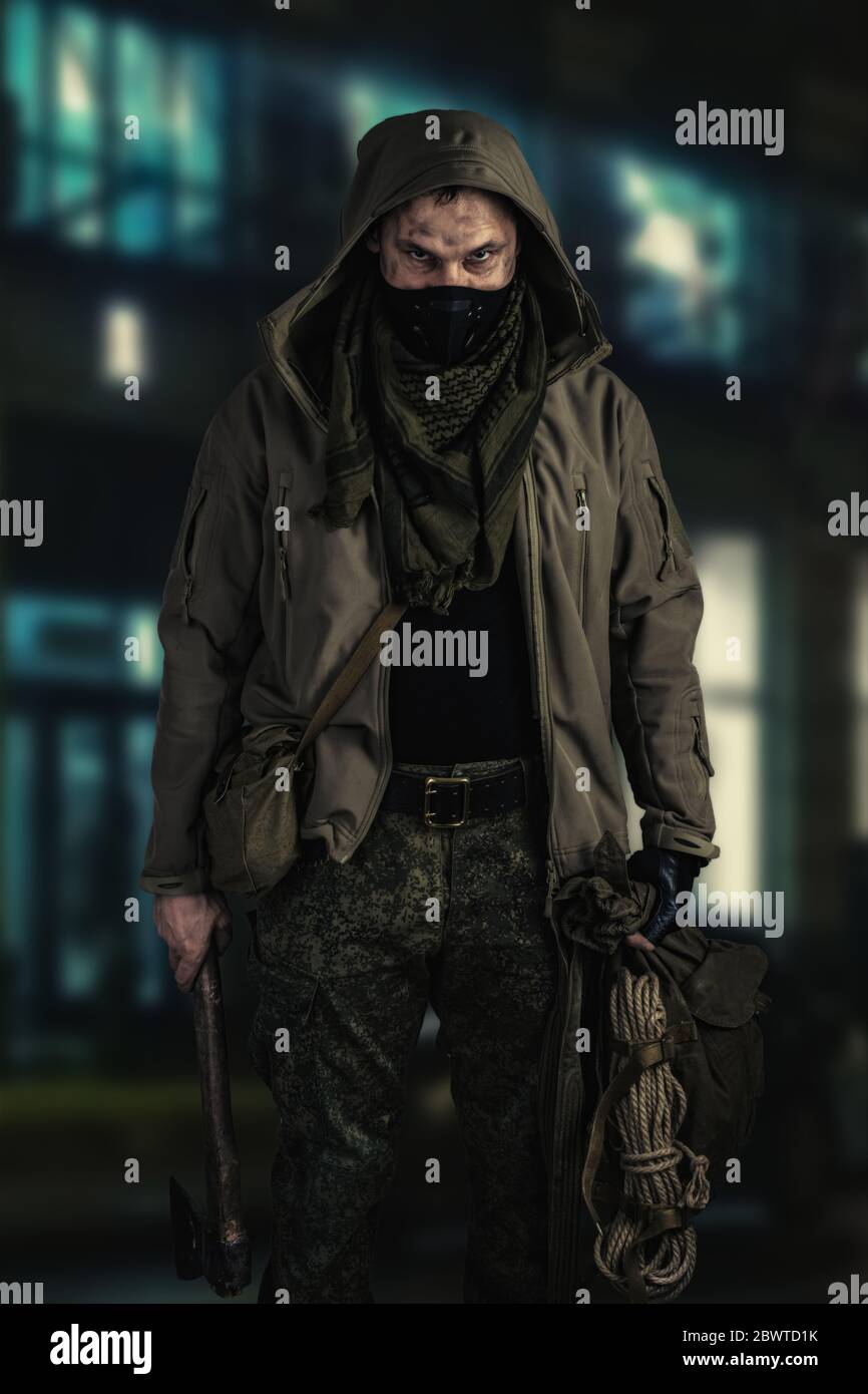 Dark photo of Young handsome man with ax wearing black protactive face ...