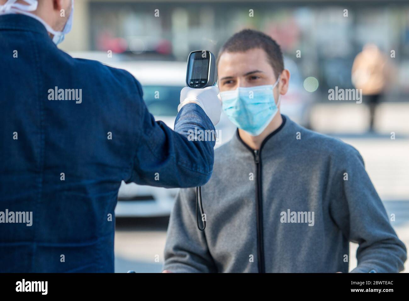 Temperature check at a supermarket of man, grocery store with thermal ...