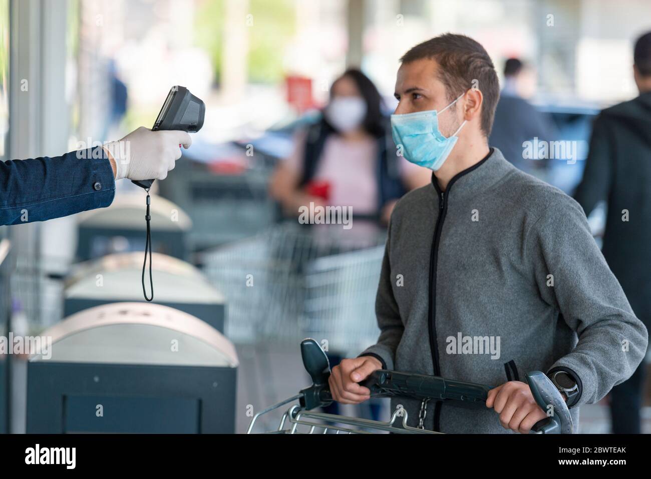Temperature check at a supermarket of man, grocery store with thermal ...