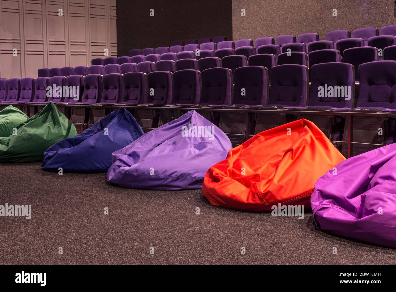 Empty comfortable red seats with numbers in cinema General plan of pink ...