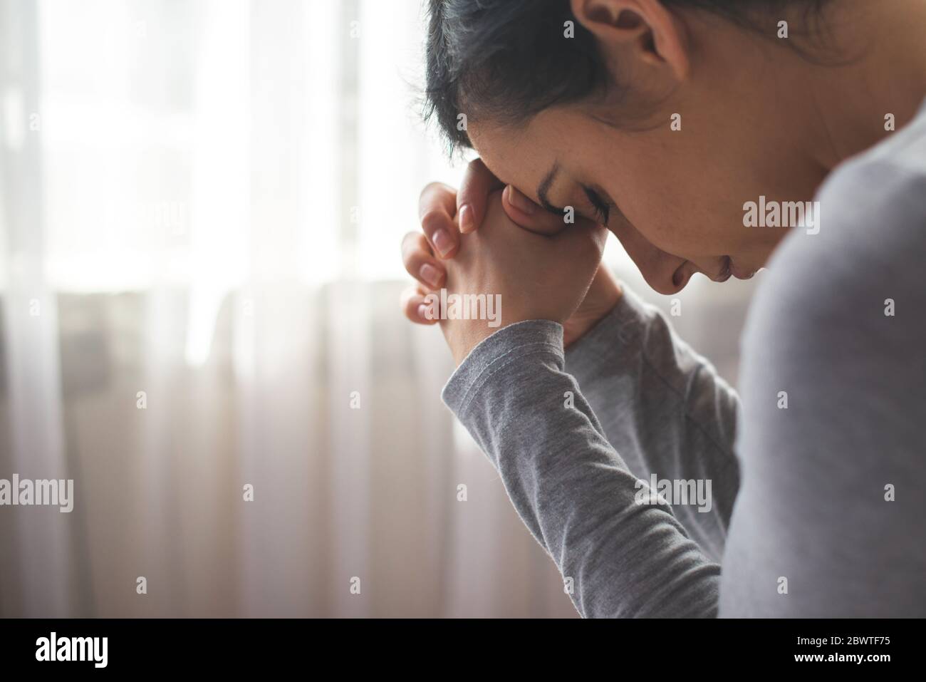 Portrait of woman praying Stock Photo - Alamy