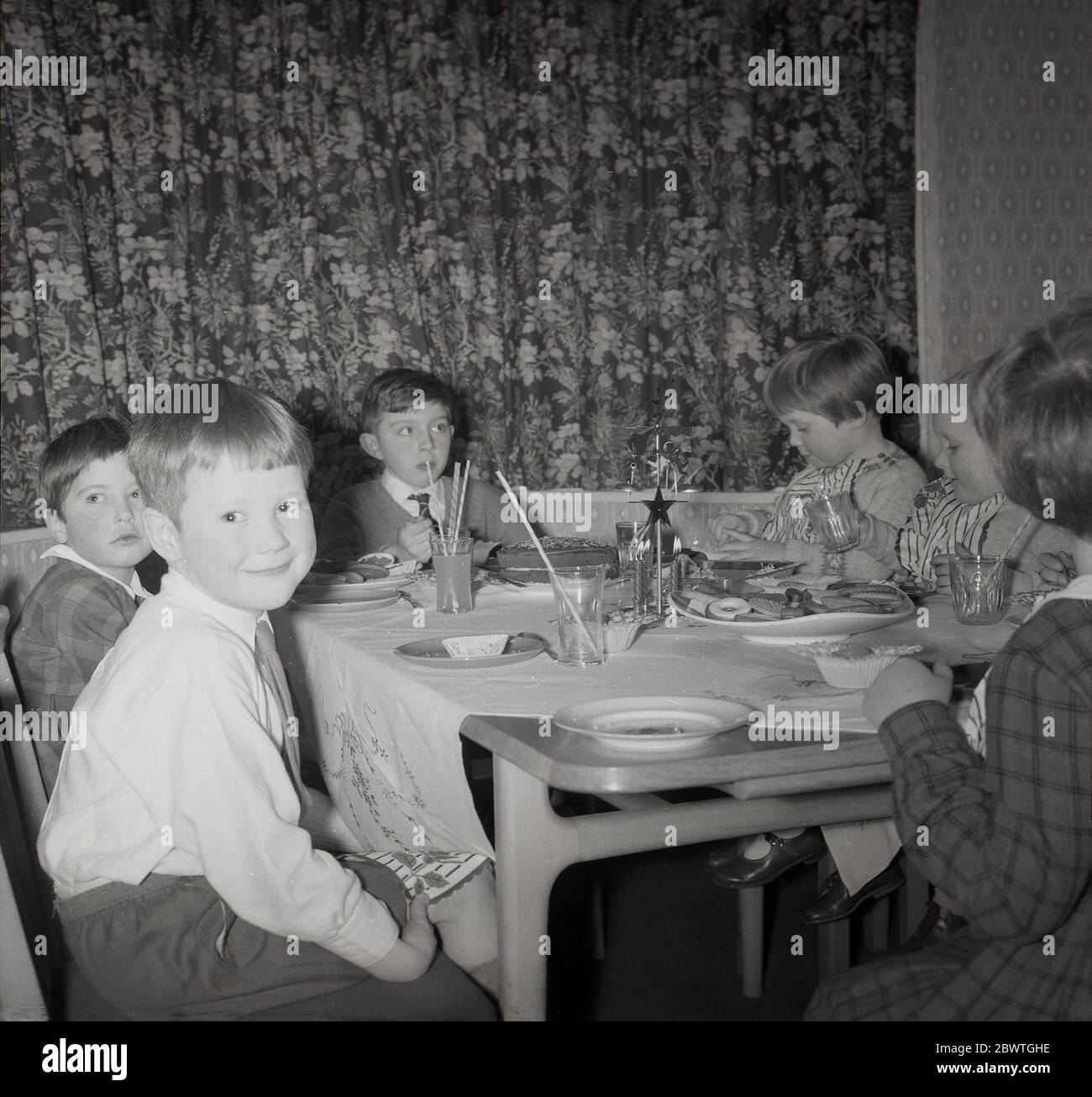 1960s, historical, young children sitting indoors at a table at a ...