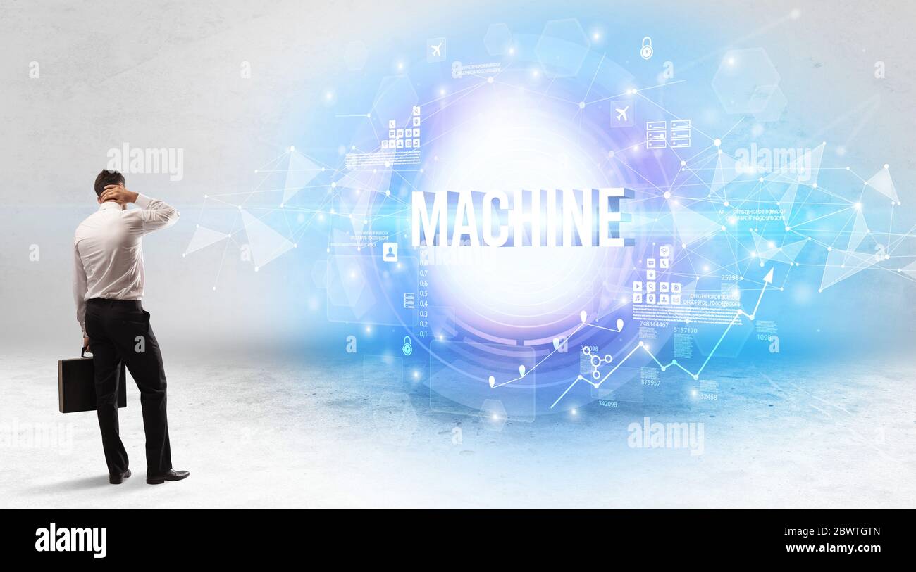 Rear view of a businessman standing in front of MACHINE inscription ...