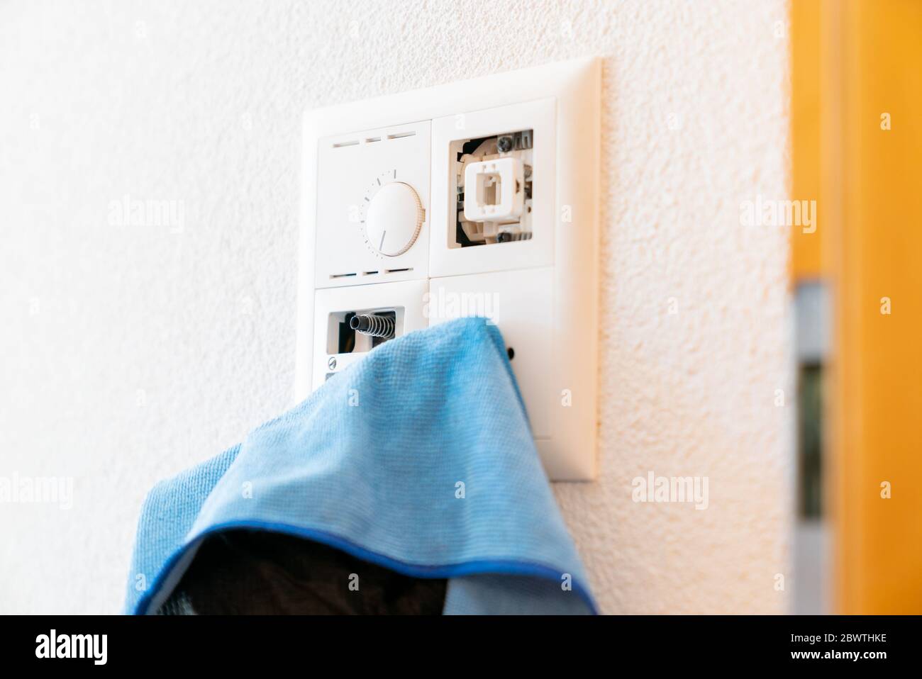 A close up of a professional cleaner cleaning a modern light switch and ...