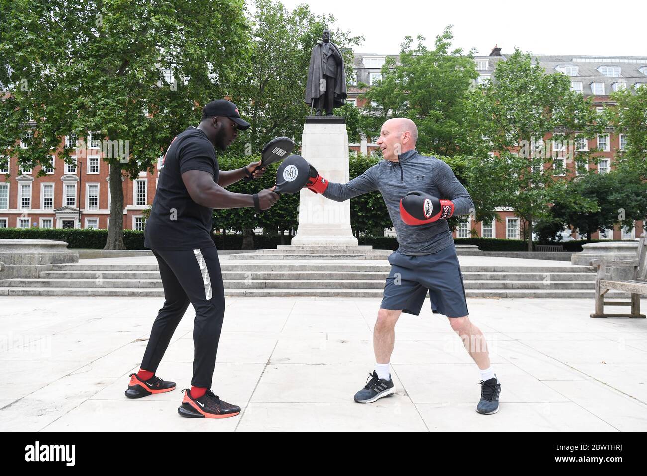 Personal trainer Michael Bossman (left) boxes with Charles Knott under ...
