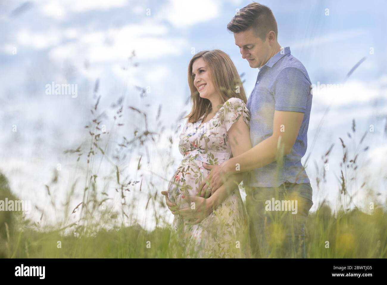 Young happy pregnant couple hugging in nature Stock Photo - Alamy