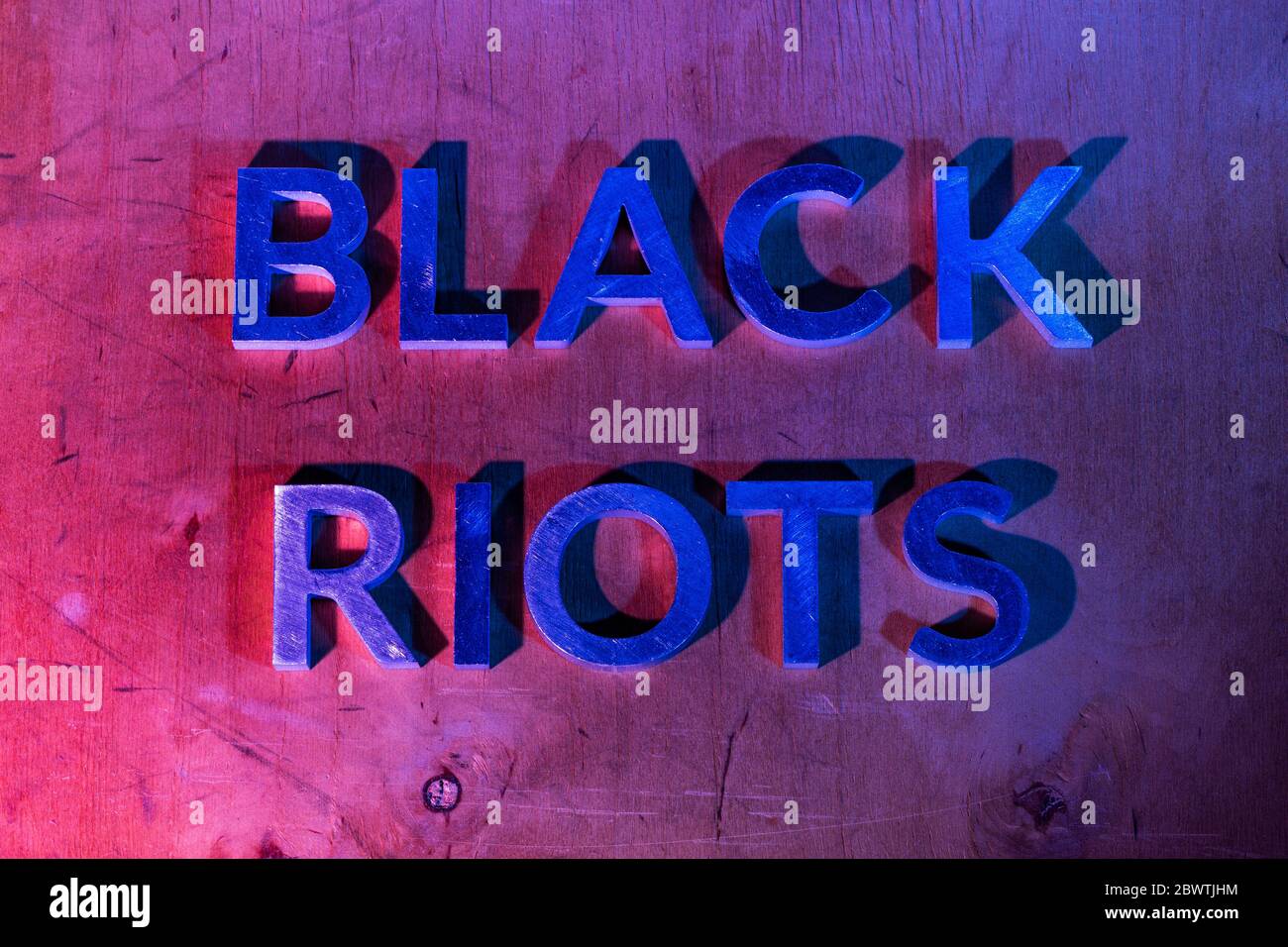 The words black riots laid with metal letters on flat plywood surface ...