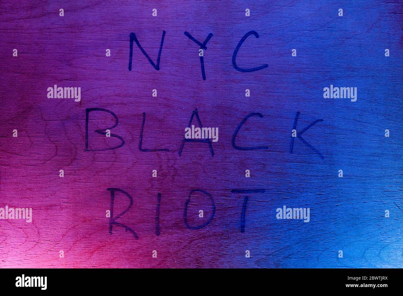 The words NYC black riot handwritten with black paint marker on flat ...