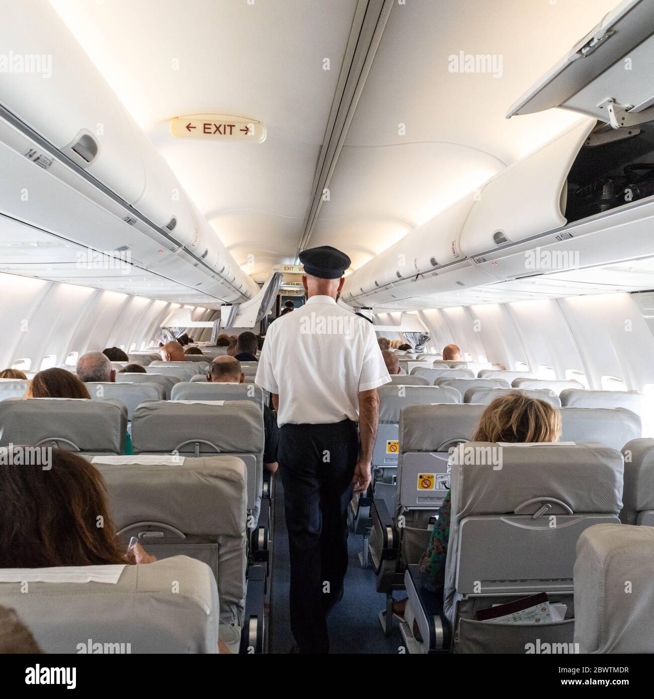 Interior of commercial airplane with flight attandant serving ...