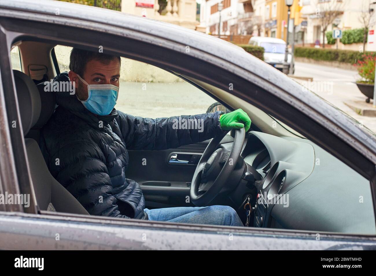 Portrait of man wearing mask driving car in city Stock Photo - Alamy