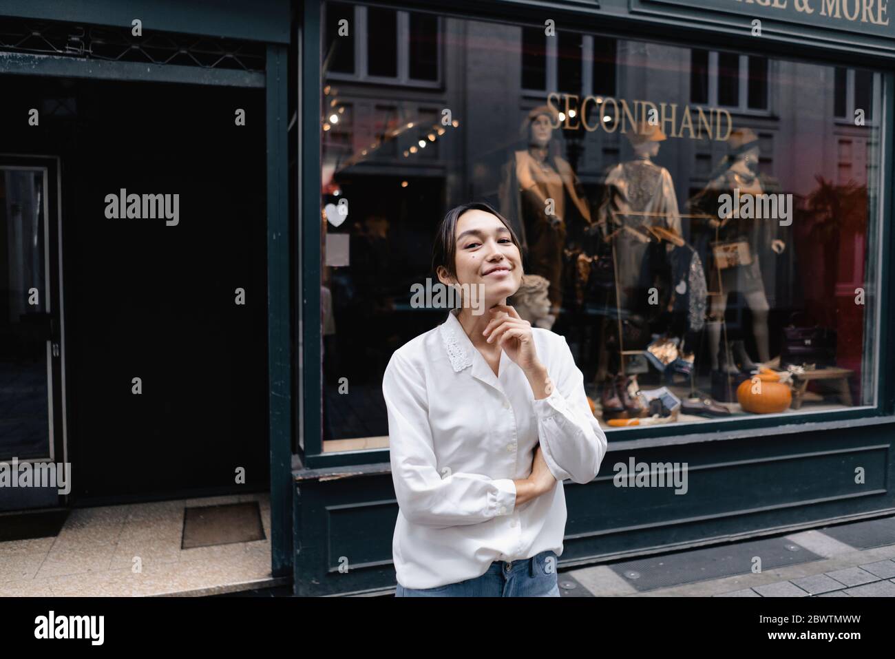 Portrait of smiling owner standing against store in city Stock Photo ...