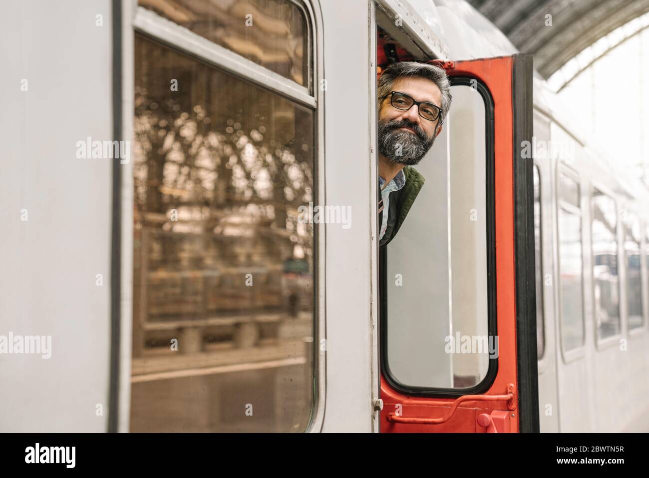 Man looking out of train Stock Photo - Alamy