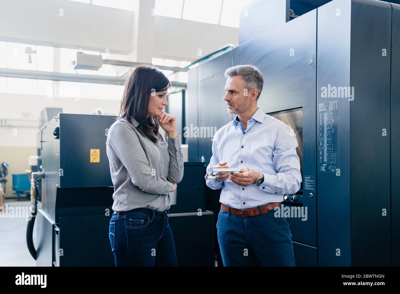 Businessman and businesswoman having a work meeting in a factory Stock ...